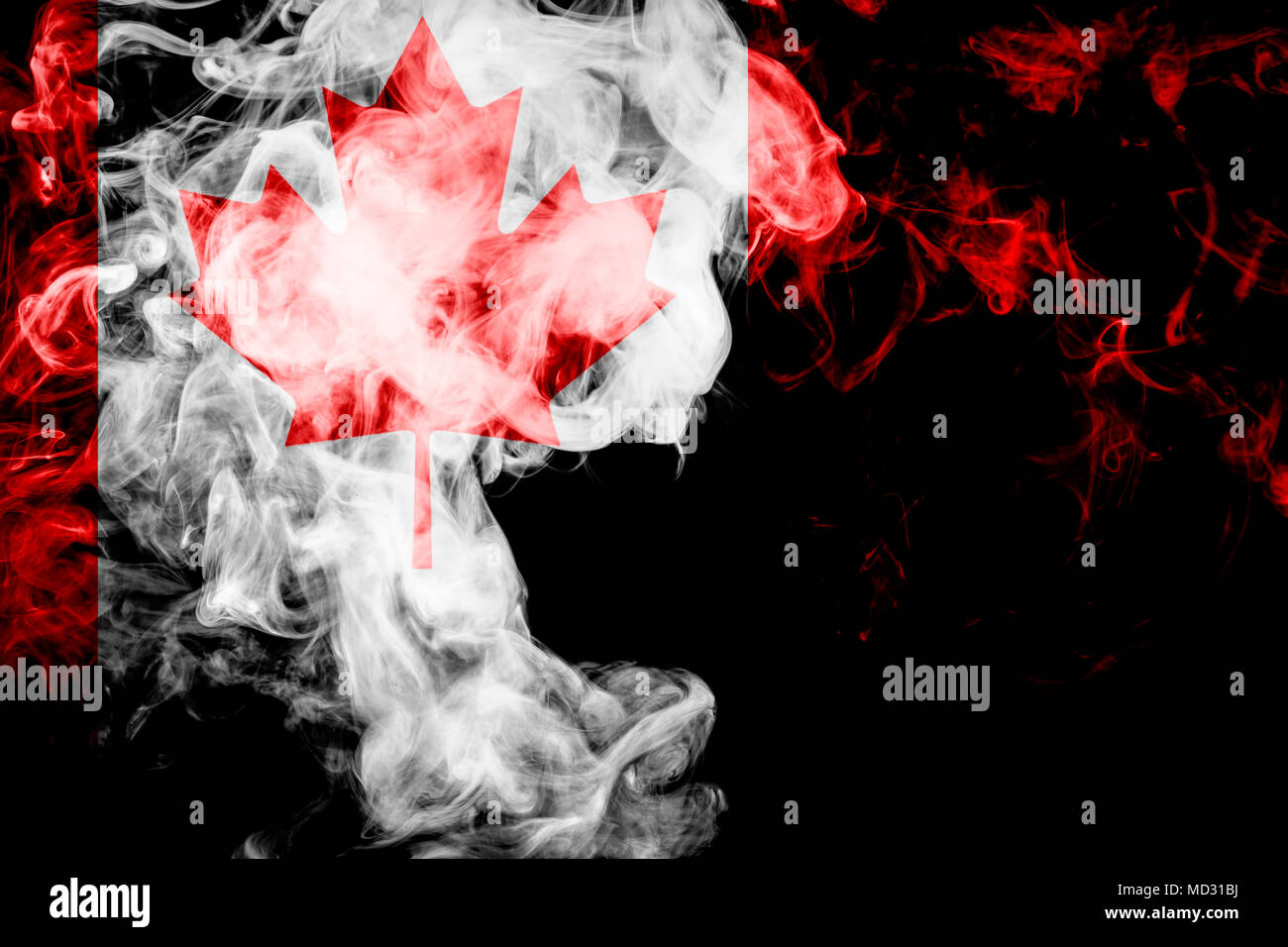 National flag of Canada from thick colored smoke on a black isolated ...
