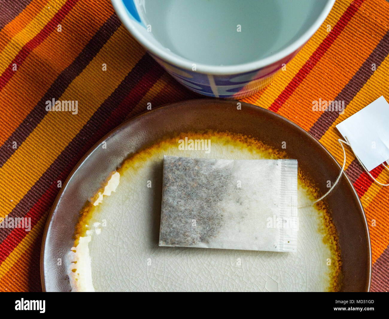 Teabag in a plate with a cup of water Stock Photo - Alamy