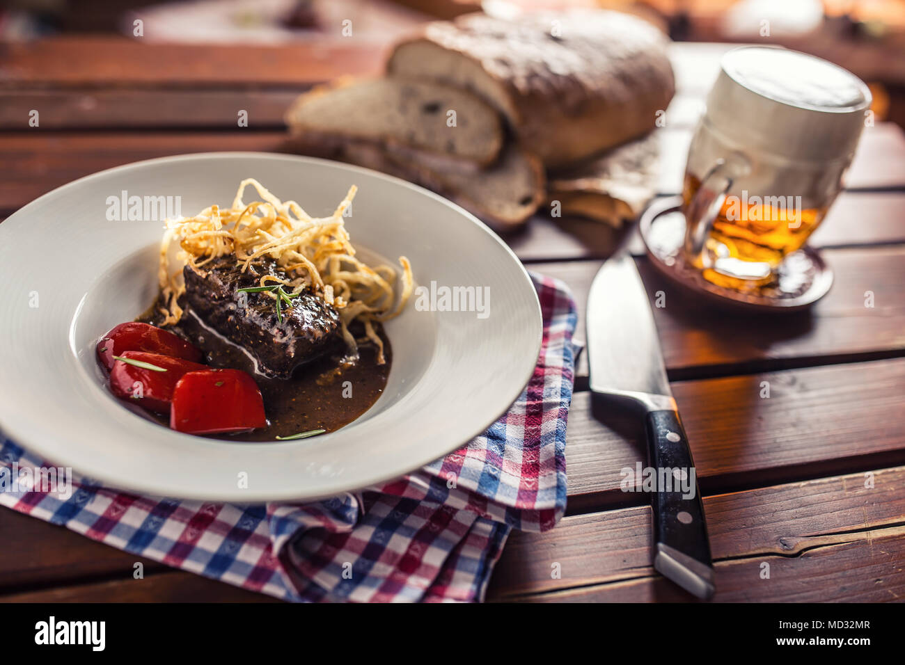 Confit beef steak with sauce fried onion bread draft beer and ...
