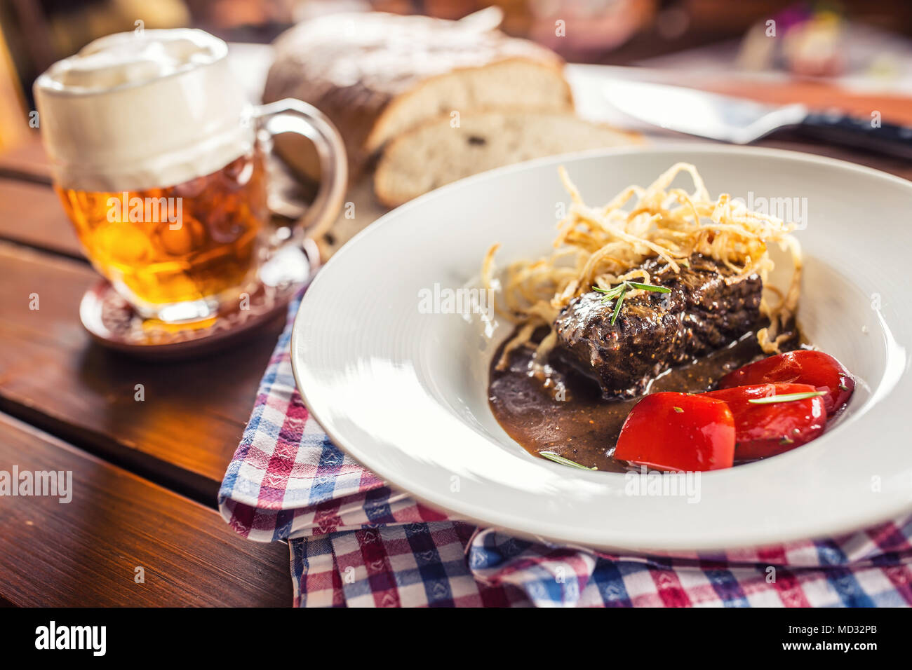 Confit beef steak with sauce fried onion bread draft beer and ...