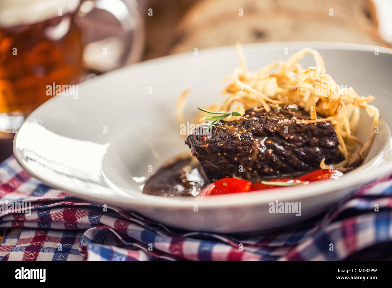 Confit beef steak with sauce fried onion bread draft beer and ...