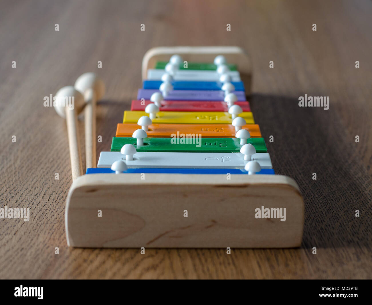 Rainbow coloured xylophone on wooden background angle view ...