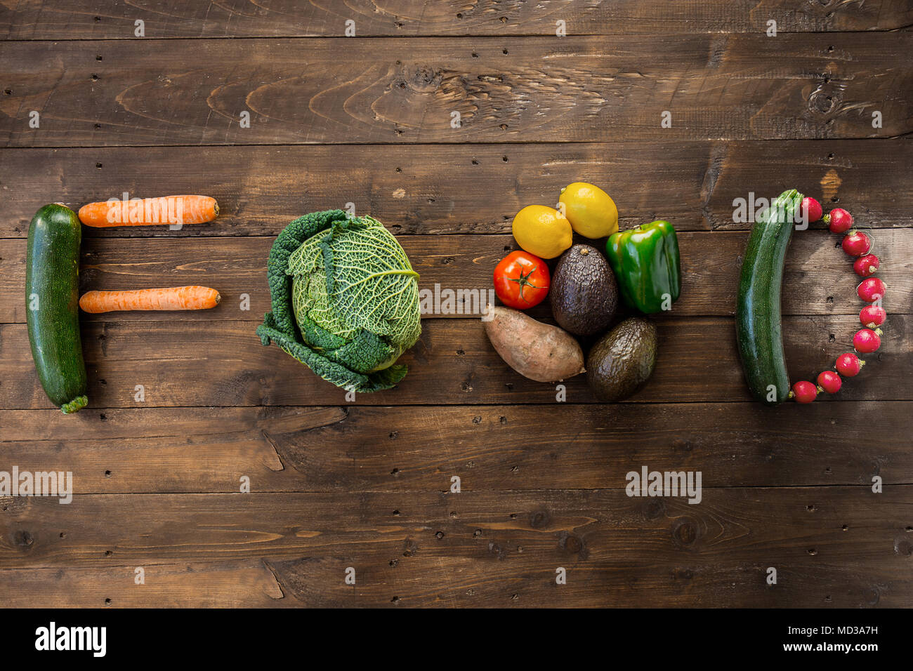 Flat lay of wooden table with word Food made of variety of fresh raw ...