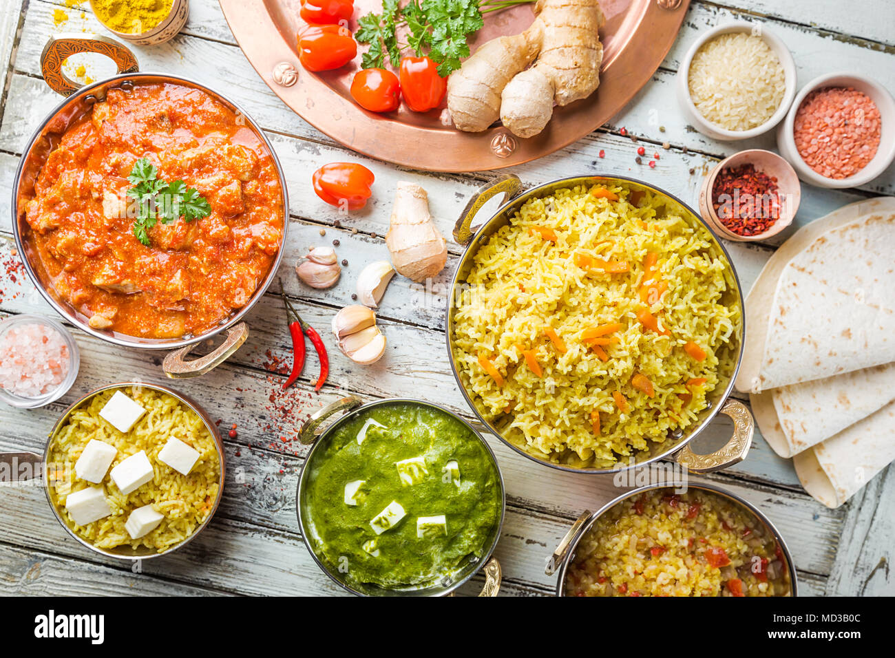 Different bowls with assorted indian food on white wooden background ...