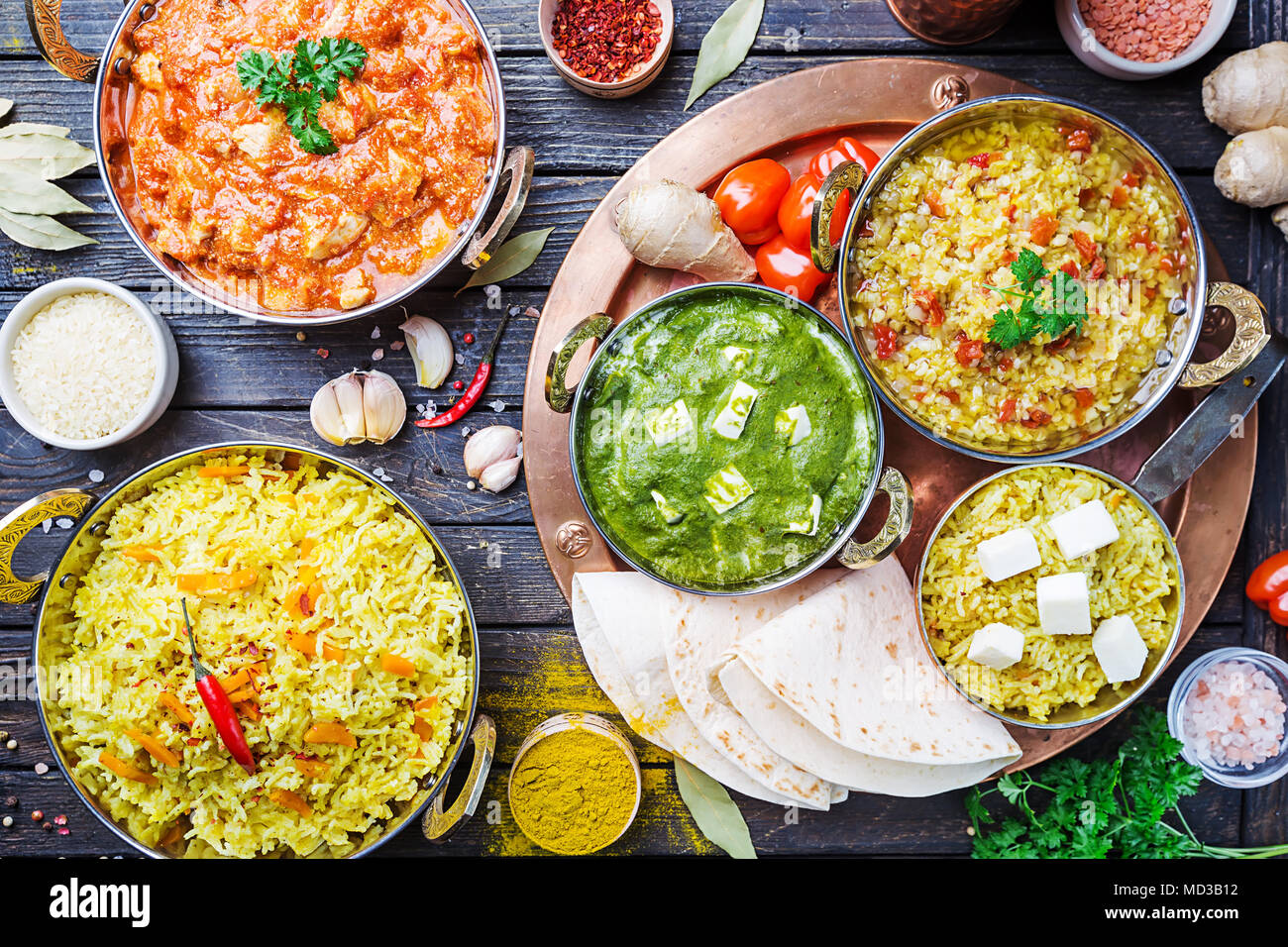 Different bowls with assorted indian food on dark wooden background ...