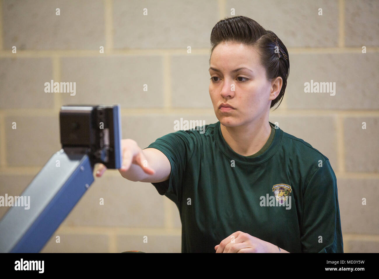U.S. Marine Corps Sgt. Amber Fifer sets her resistance on the rowing ...