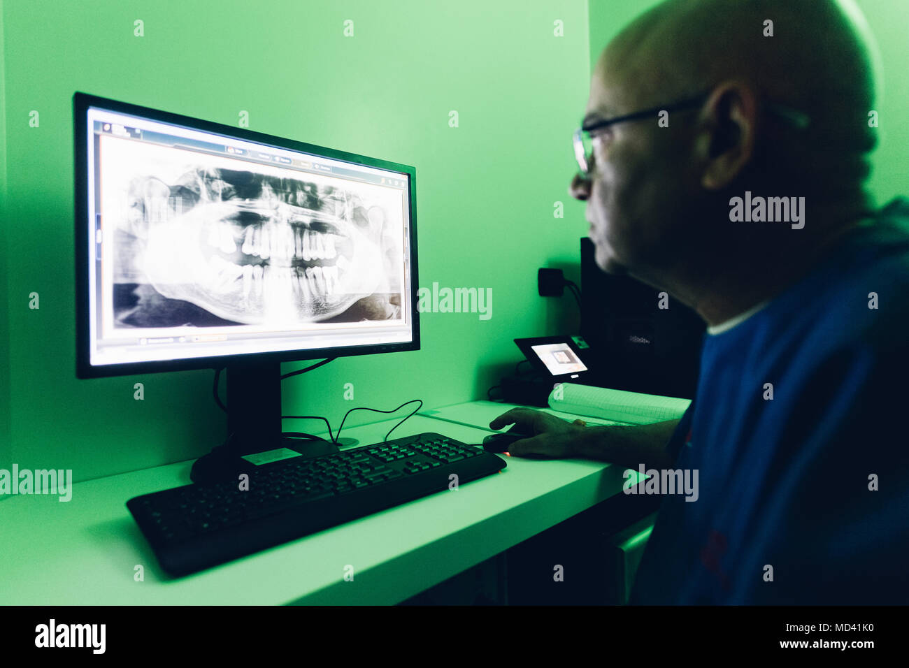 Dentist looking at dental x-ray on computer Stock Photo - Alamy