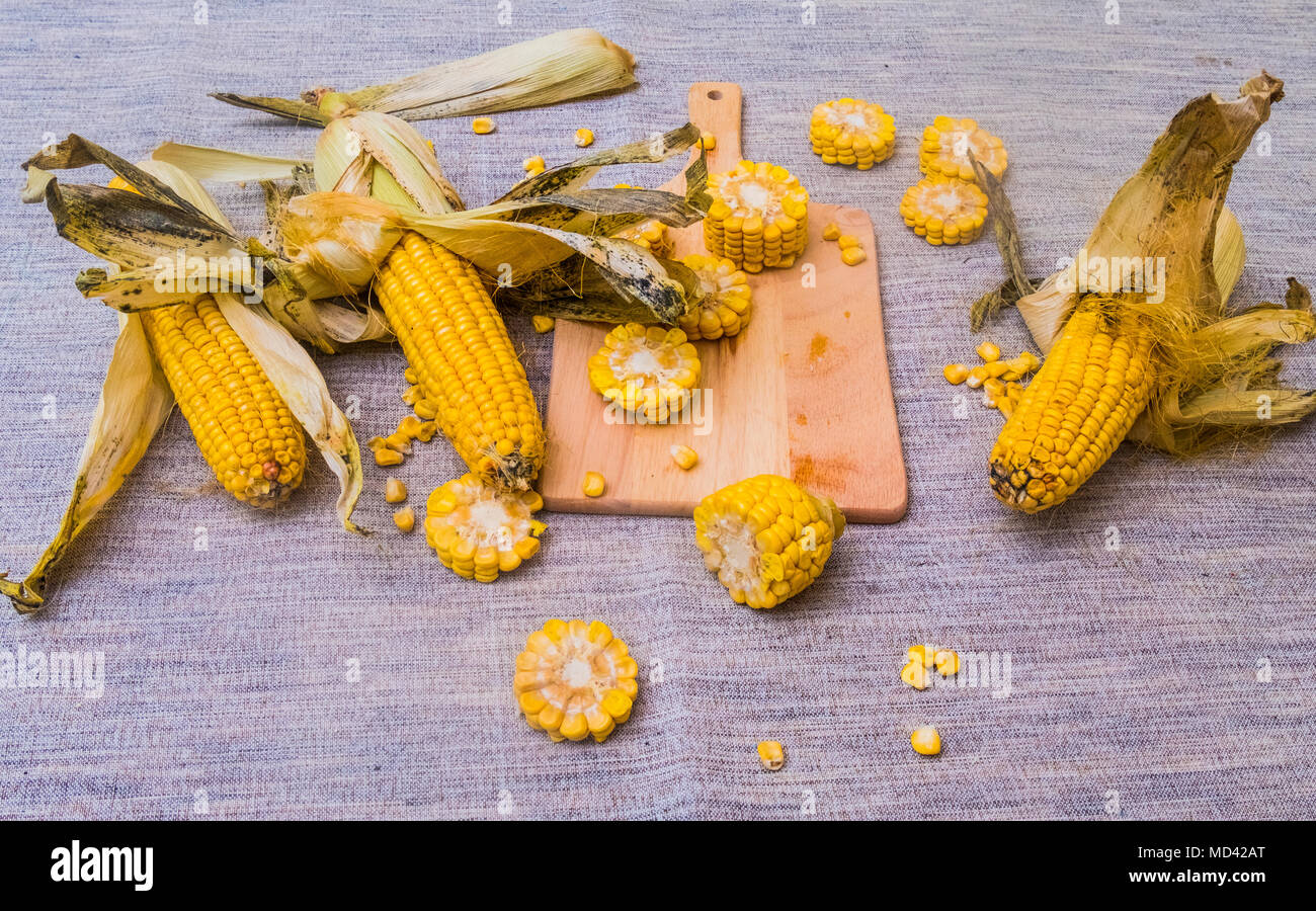 Sliced corn on the cob on chopping board, with whole corn on cob Stock ...