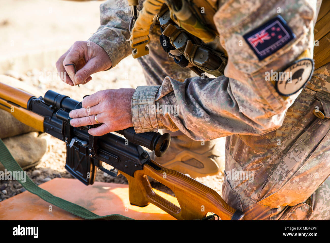 A New Zealand defense member, with Task Force Taji, adjusts the ...