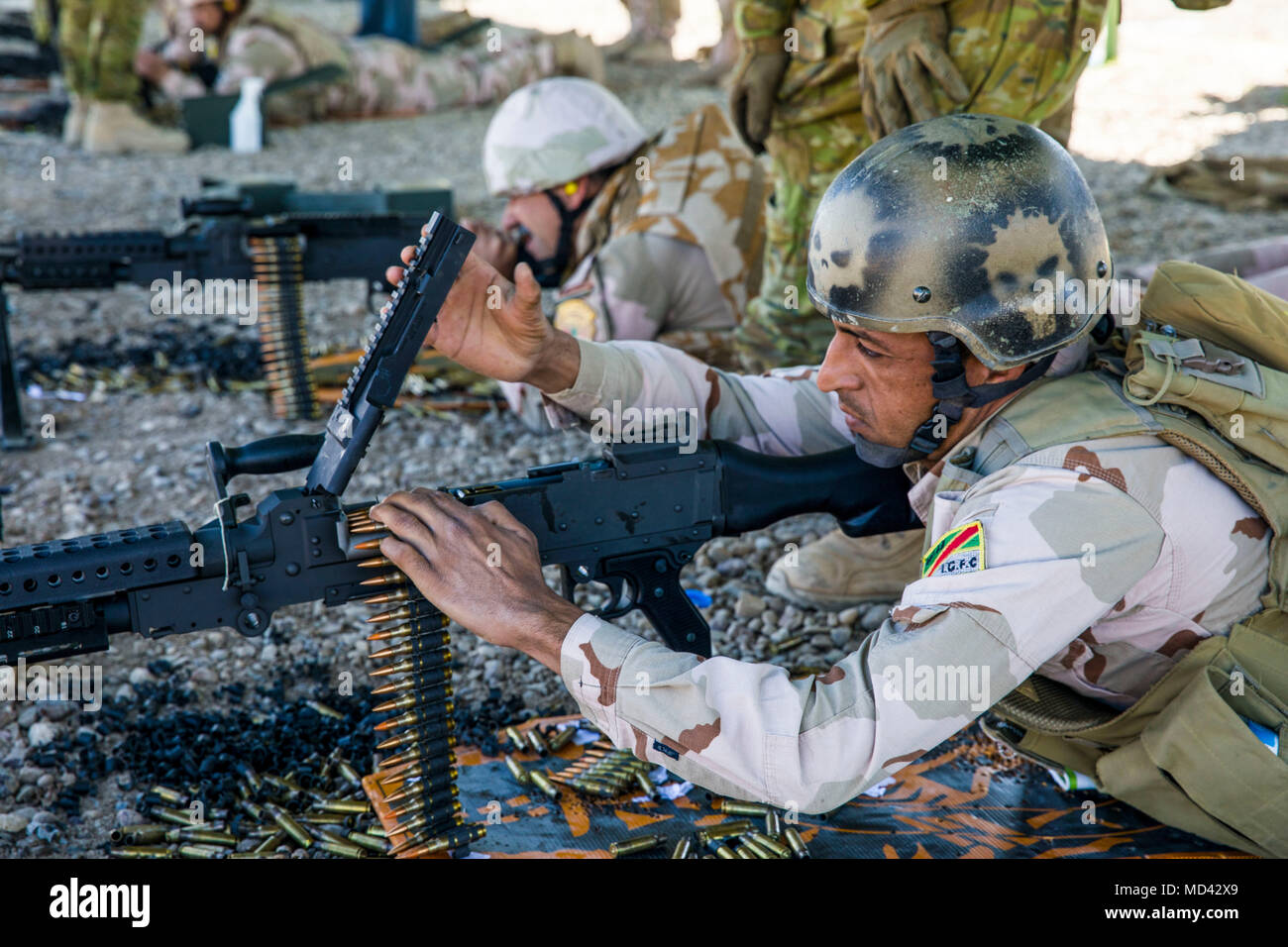 An Iraqi soldier assigned to 74th Brigade loads an M240B machine gun ...