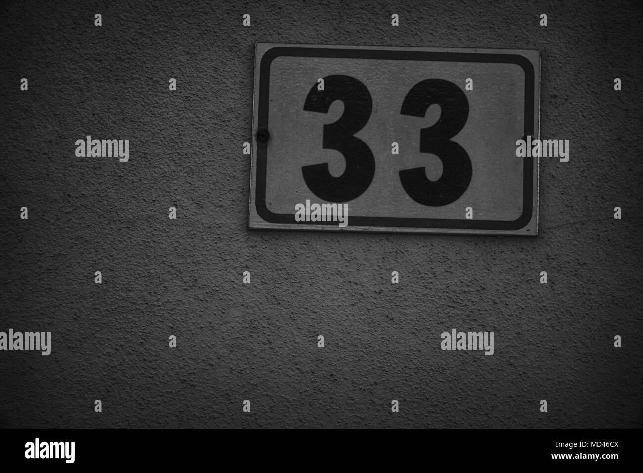Street number 33 on beige wall, background for web site or mobile ...