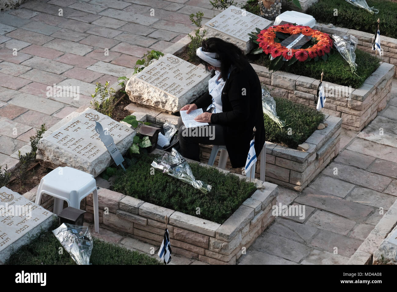 A Jewish woman praying at the grave of an Israeli fallen soldier on Yom ...