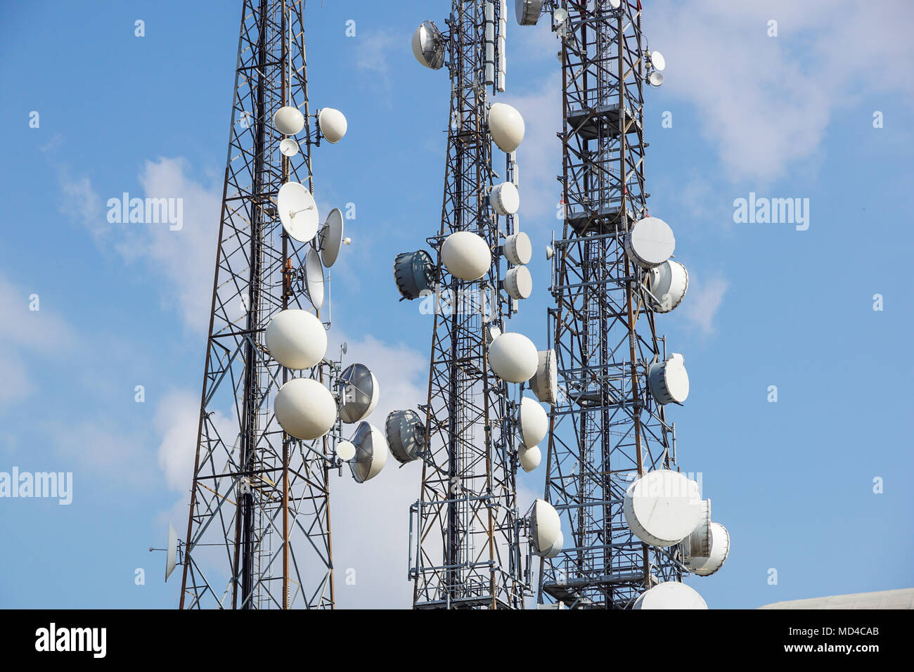 Mobile phone communication antenna tower with satellite dish on blue ...