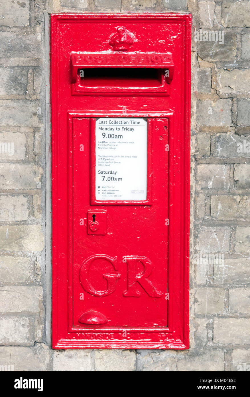 Traditional red GR British post box set into a brick wall, with royal ...