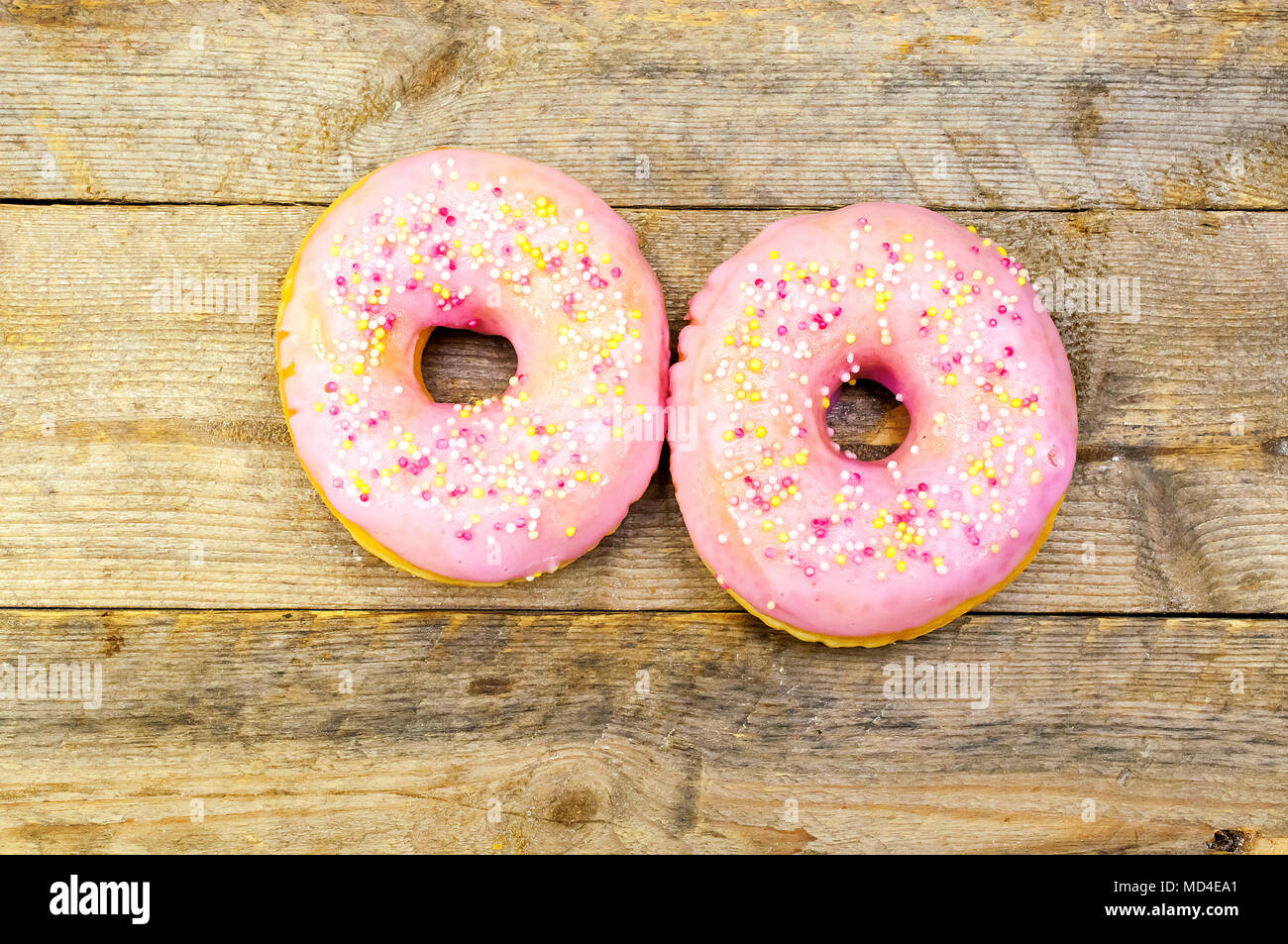Two sweet donut with pink frosting and sprinkles Stock Photo - Alamy