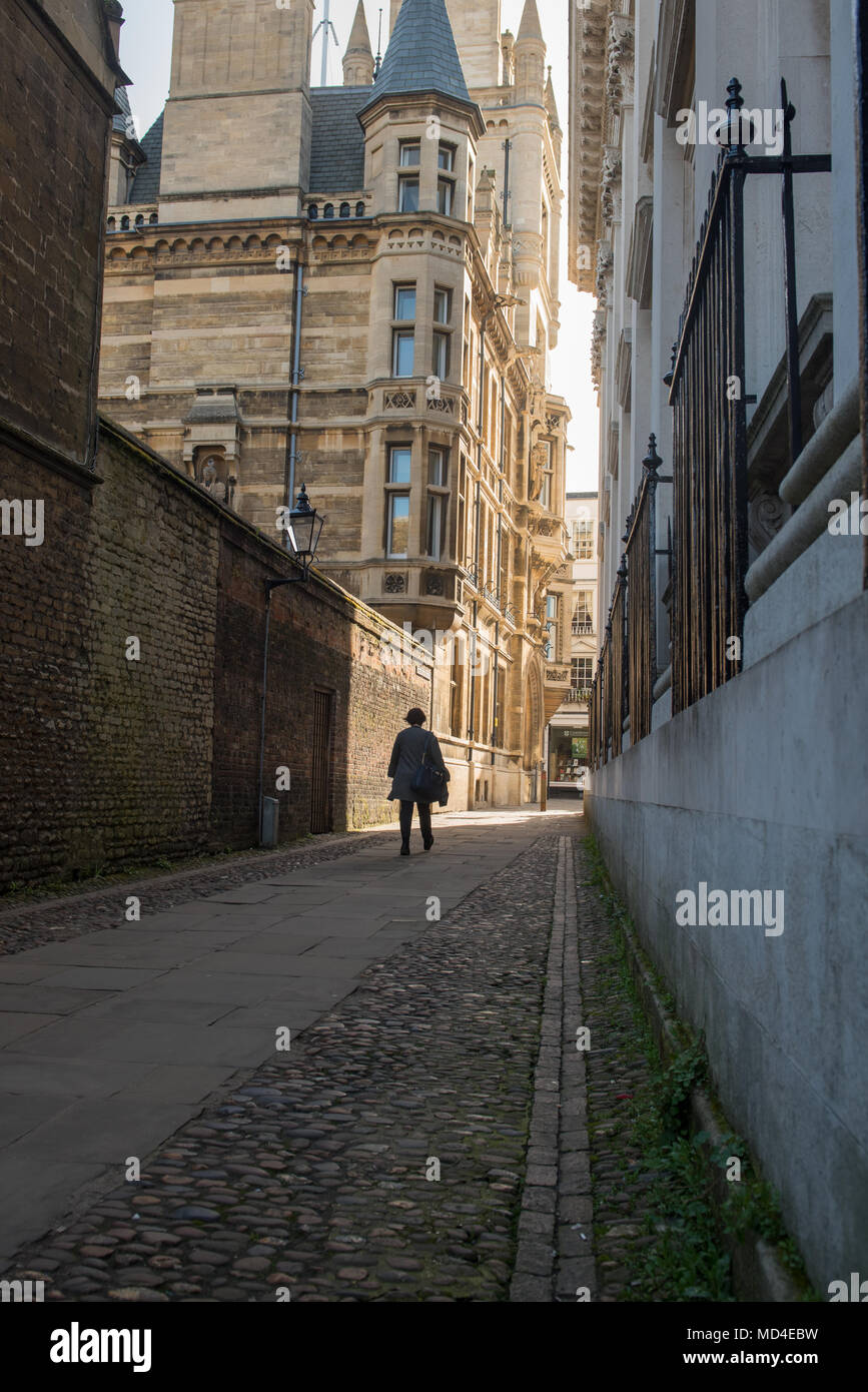 Person walks through a narrow alleyway in Cambridge, UK, lined with ...