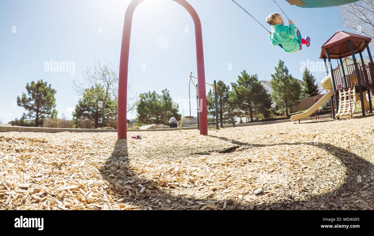 Little girl playing on outdoor childrens playground in suburbs Stock ...