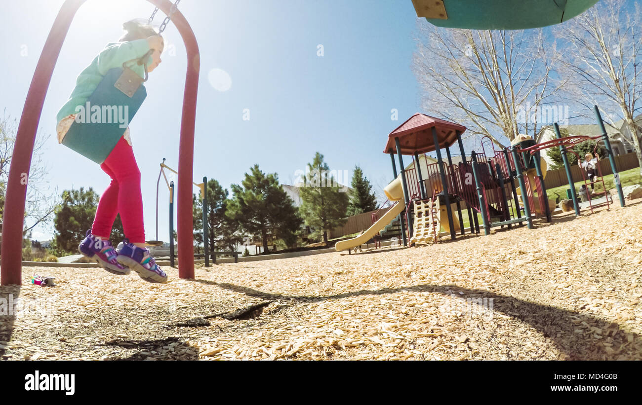 Little girl playing on outdoor childrens playground in suburbs Stock ...