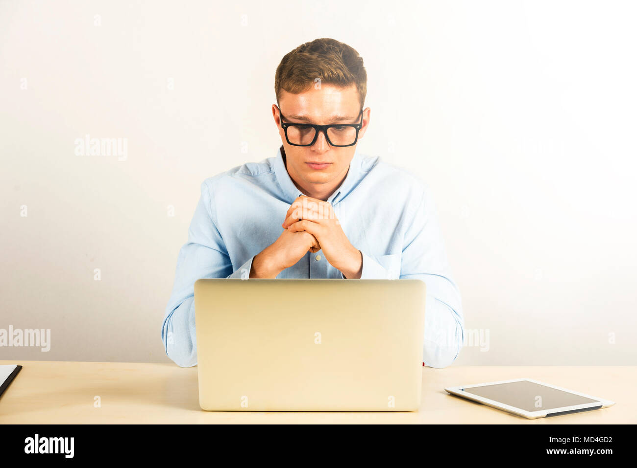 Young man using laptop in the office by the desk, thinking pose Stock ...