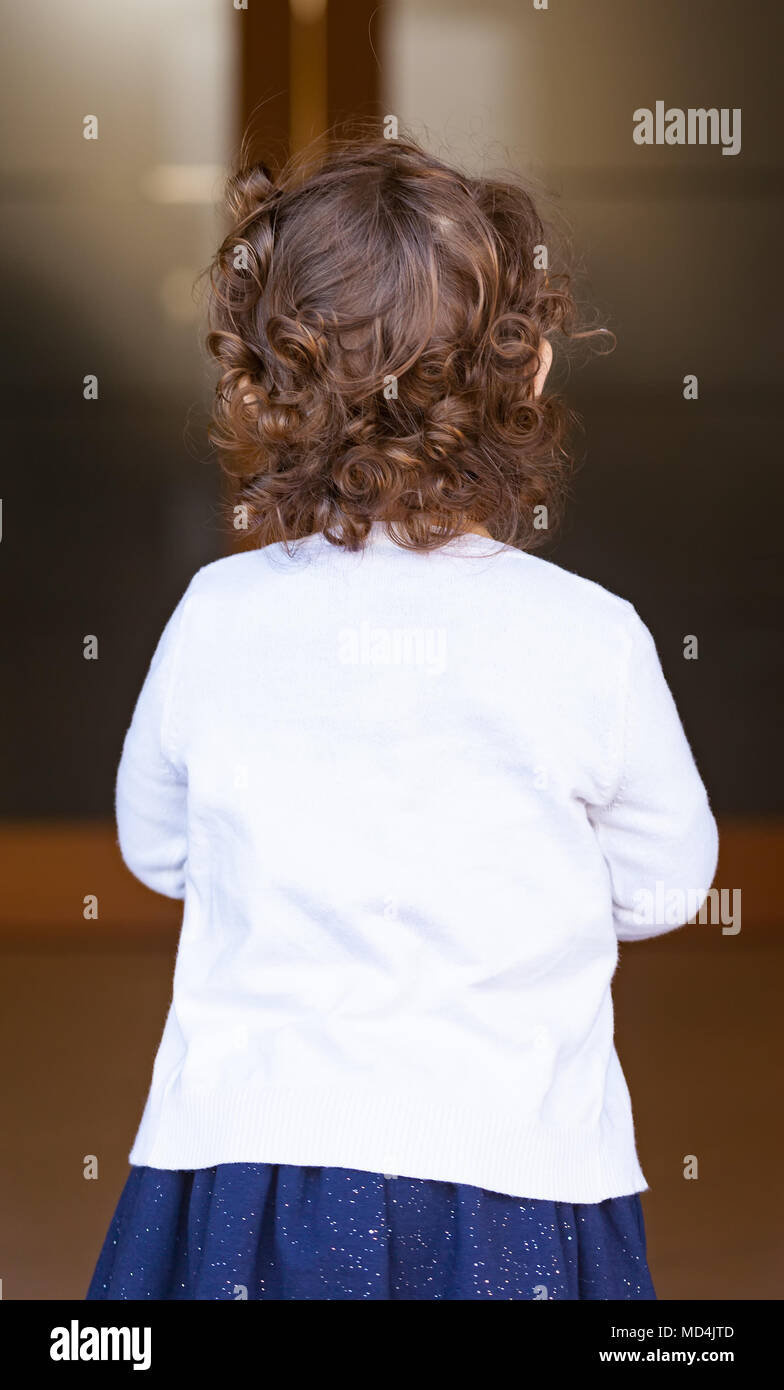 Beautiful baby girl from behind with curly hair Stock Photo - Alamy
