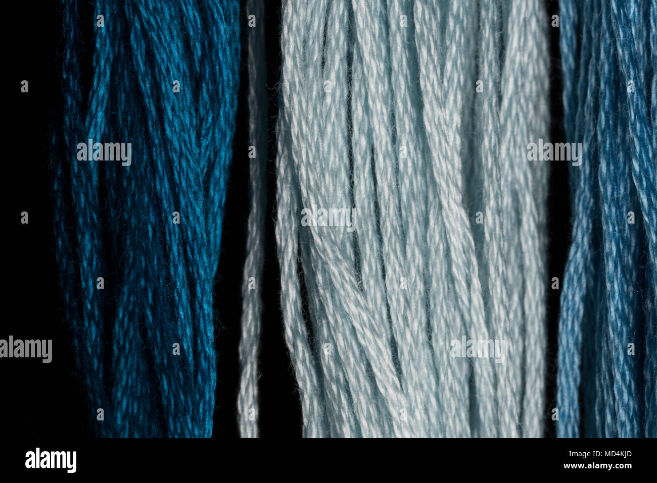 deep blue, blue, light blue and white cotton threads macro close up ...