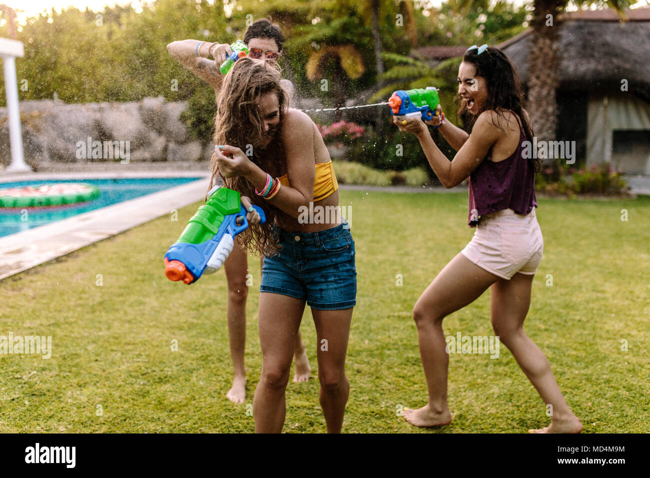 Young friends having water fight hi-res stock photography and images ...