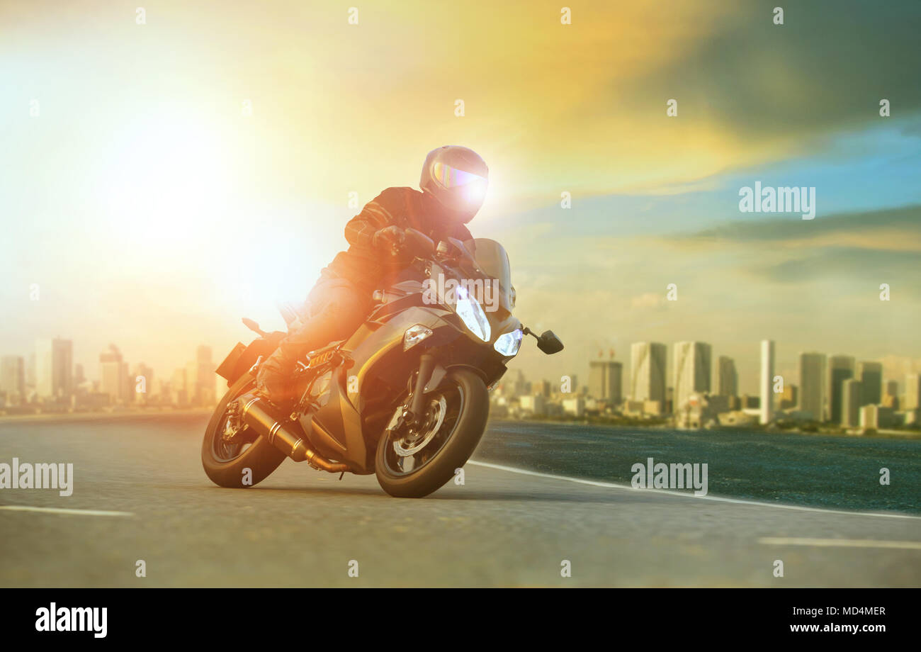 young man riding big motorcycle leaning on sharp curve with urban ...
