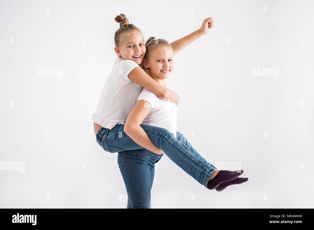 Portrait of a young, happy girl having fun, enjoying a piggyback ride ...