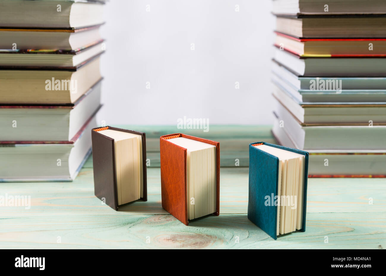 Pile of various books on bright wooden background. With copy space for ...