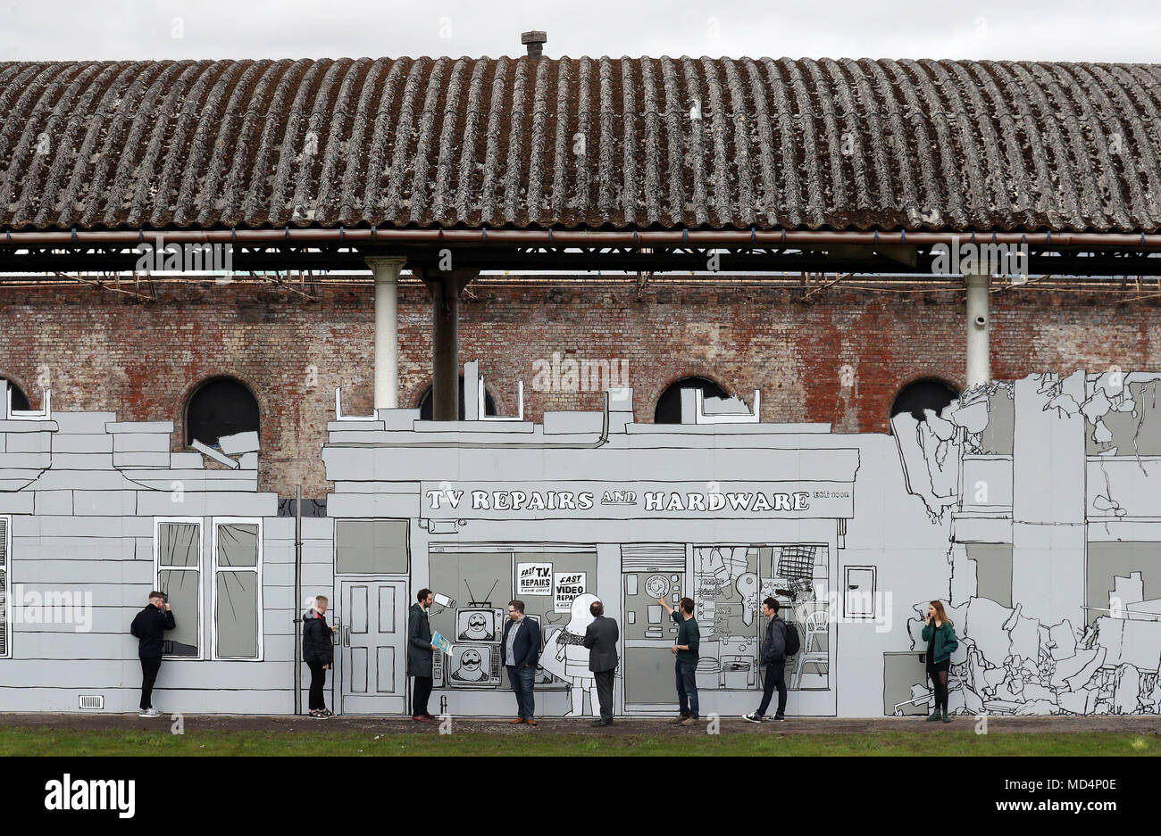 Artist Mick Peter alongside members of the public as they stand beside ...