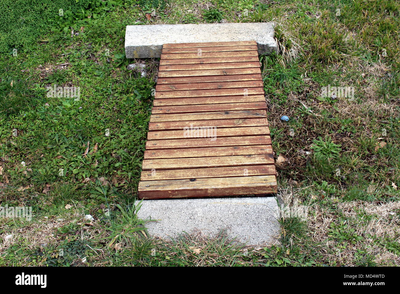 Homemade small heavily used wooden bridge connected with two stone ...