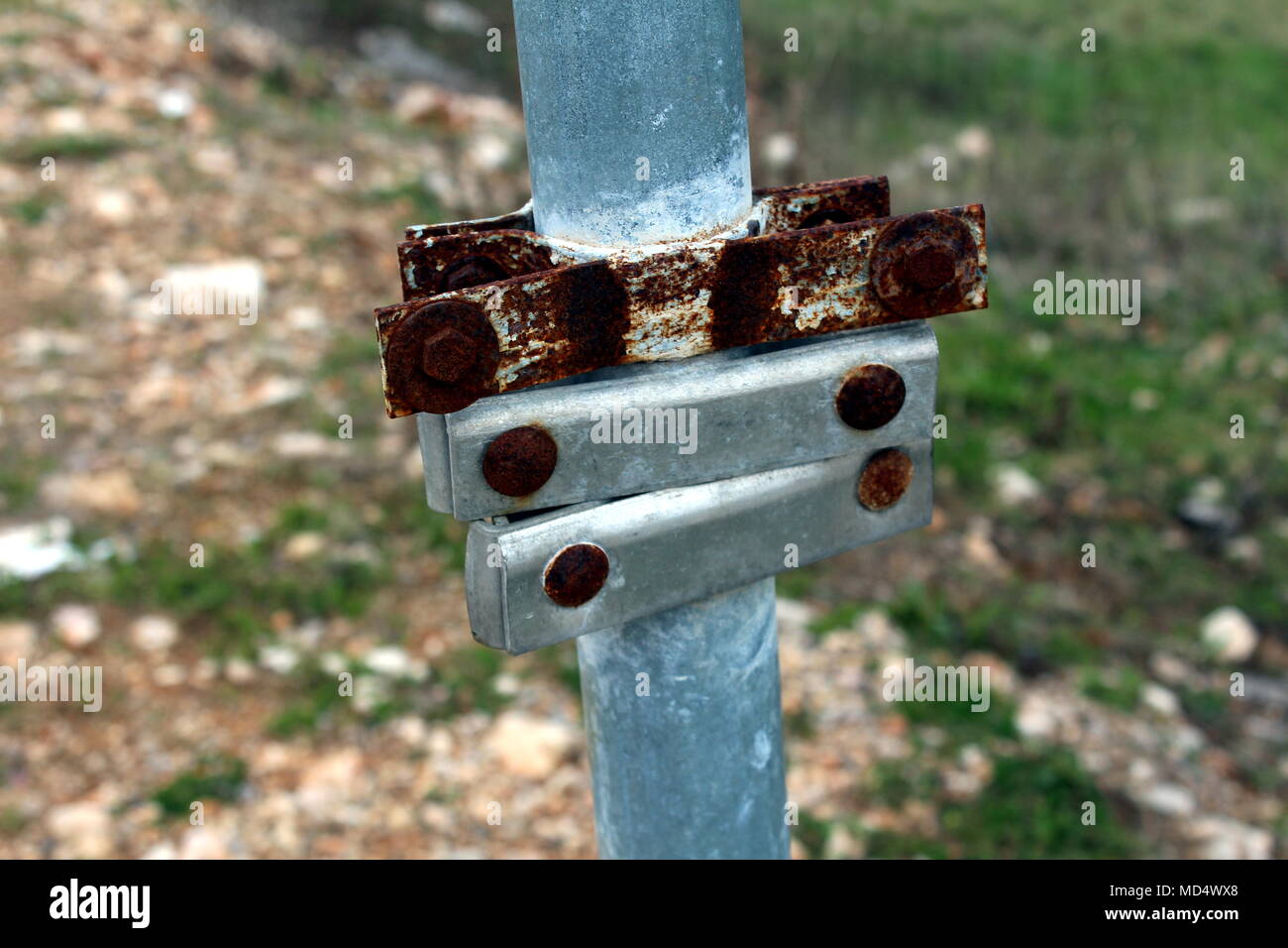Rusted and new metal round post mount brackets for holding signs ...