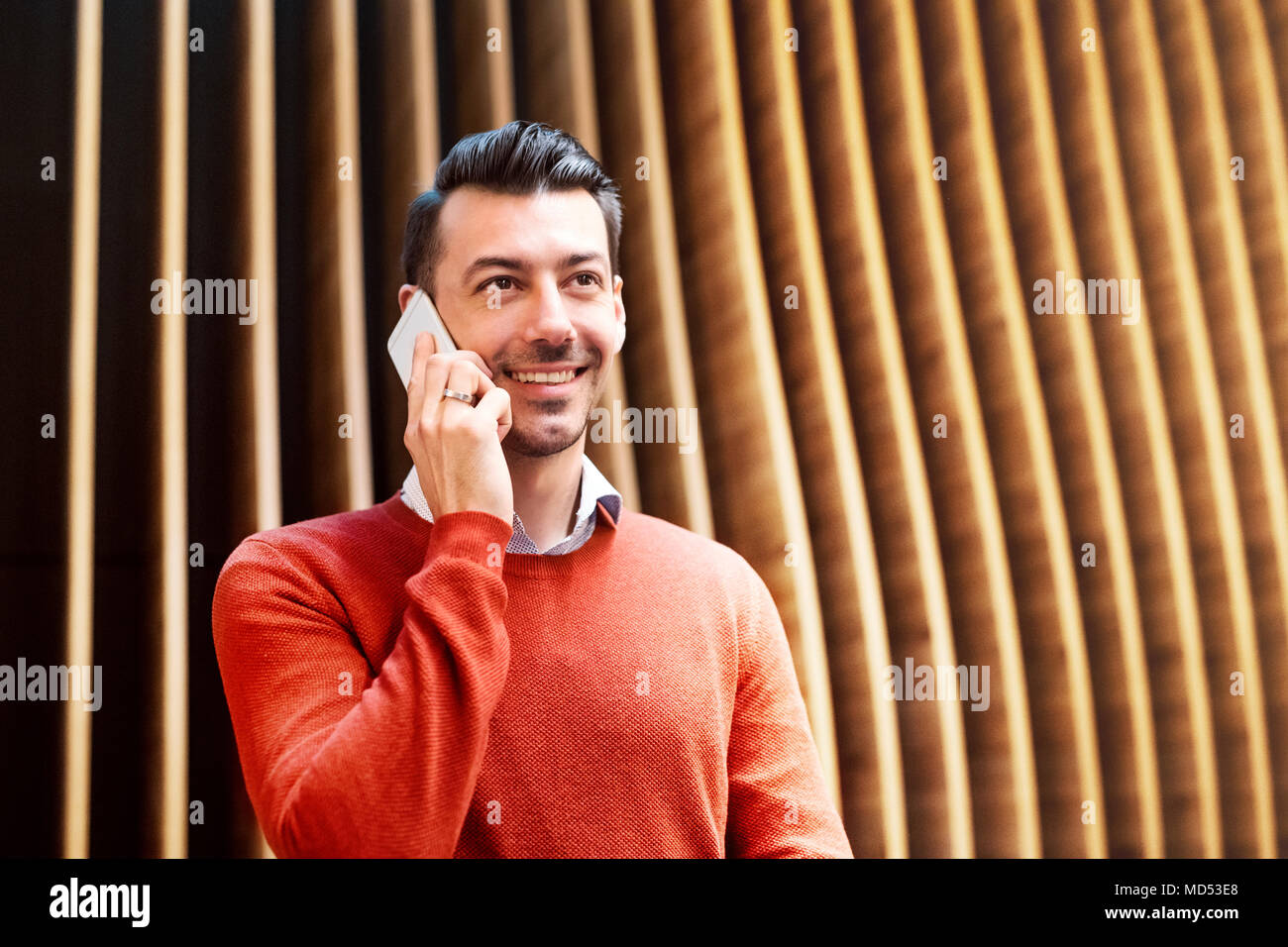 Young man with smartphone standing against wooden wall Stock Photo - Alamy