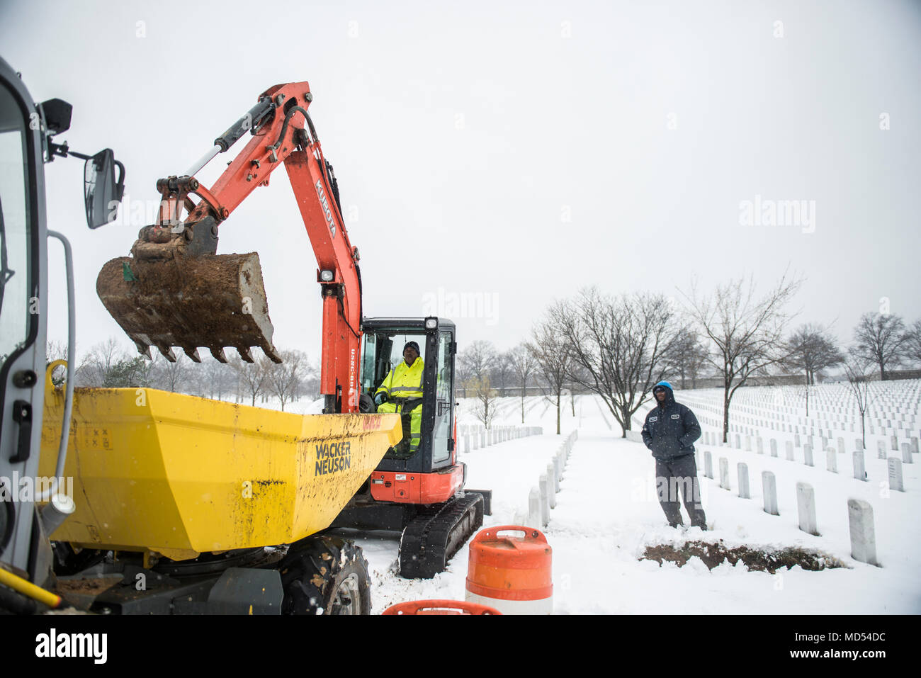 Field Operations teams use excavators and other equipment to dig graves ...