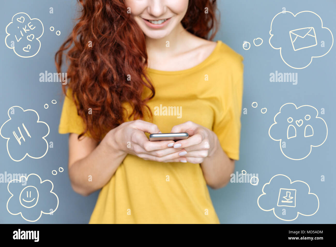 Cheerful student smiling while sending messages to her friends Stock ...