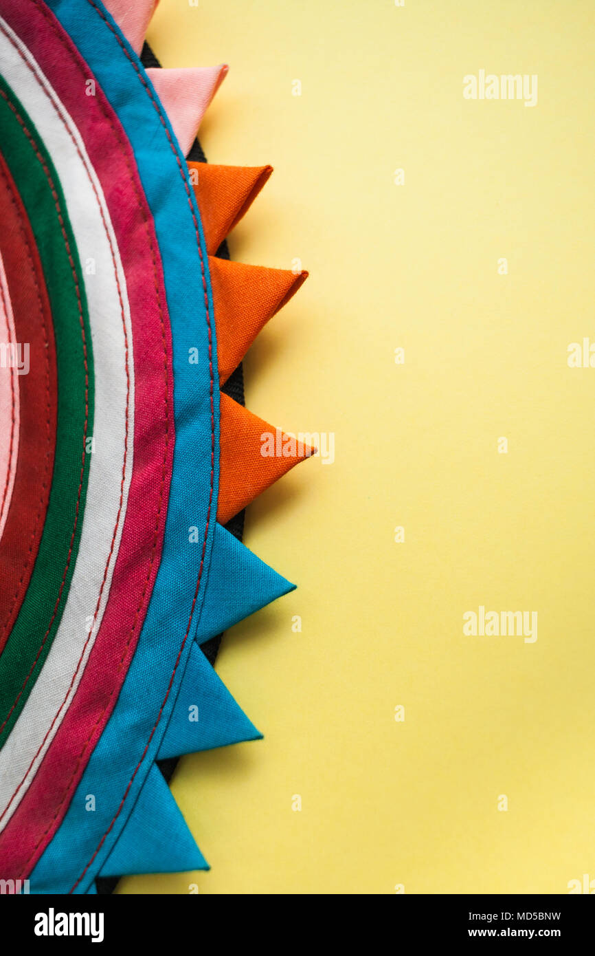Circular handmade striped cloth on the left and bright pastel yellow ...