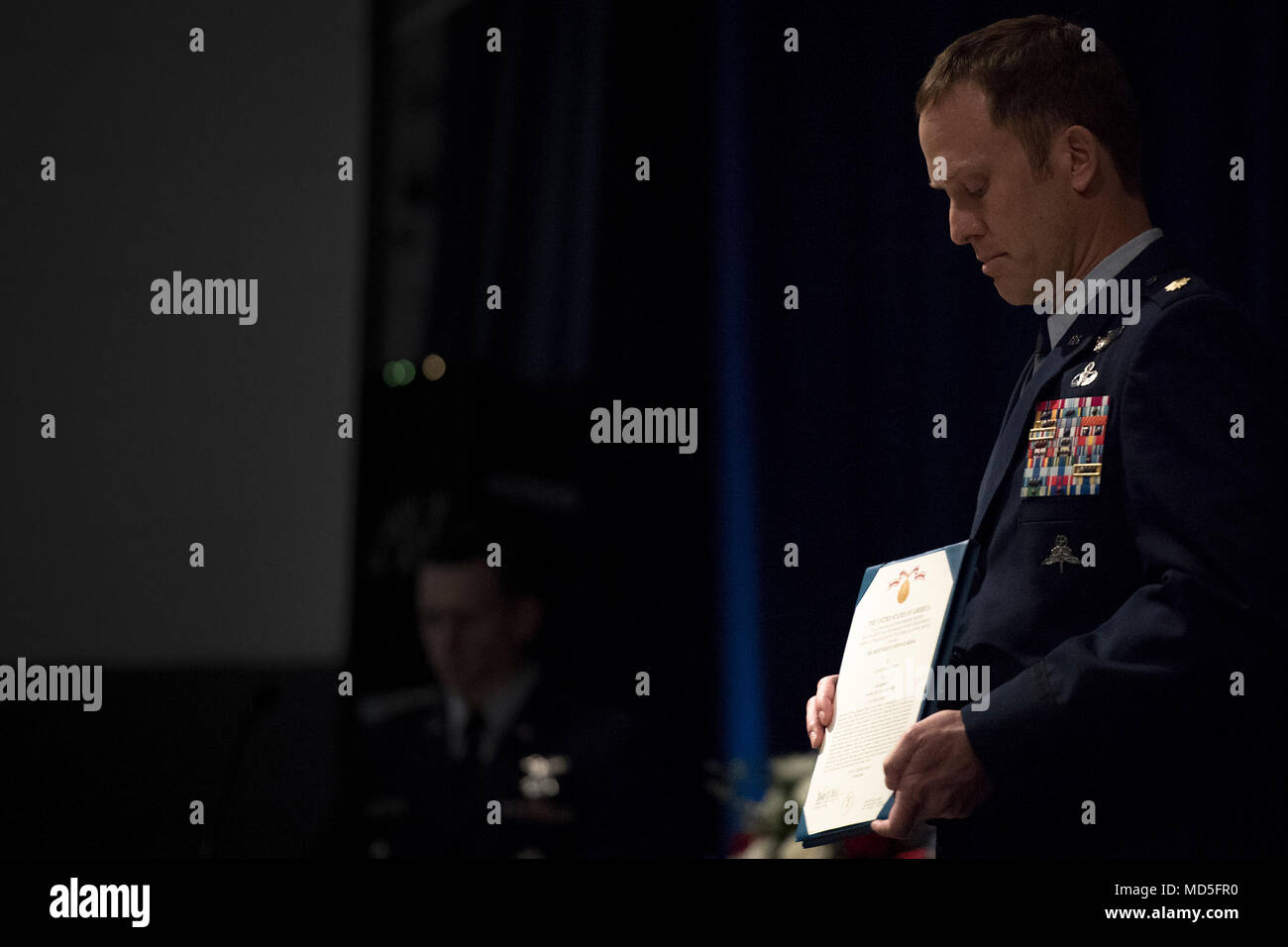 Maj. Jason Egger, 38th Rescue Squadron commander, presents a Meritorious Service Medal citation ...