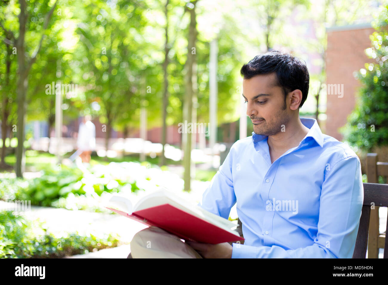 Closeup portrait young business man reading red book, relaxing on ...