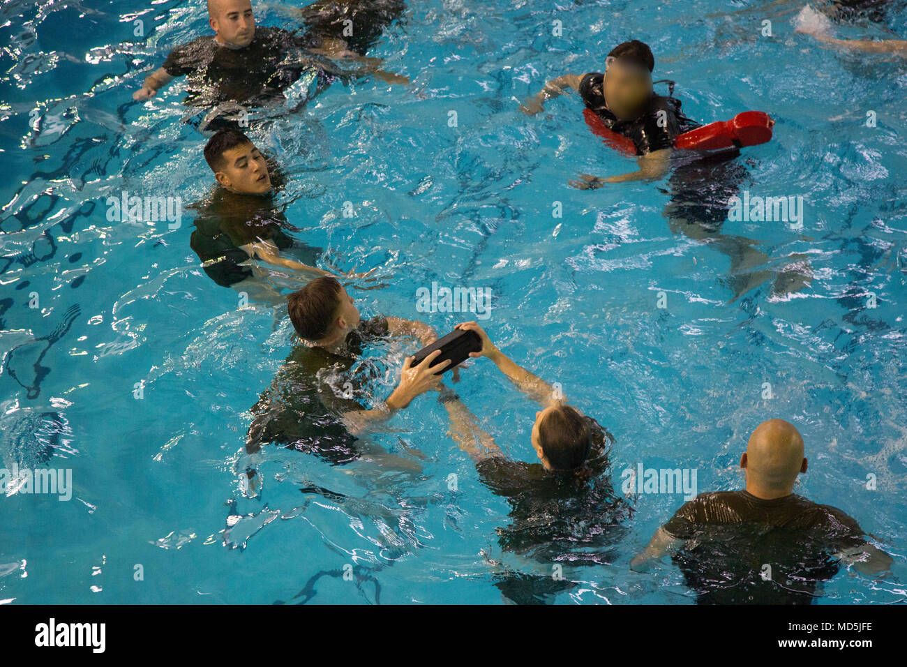 Marines pass a brick to one another while participating in water ...