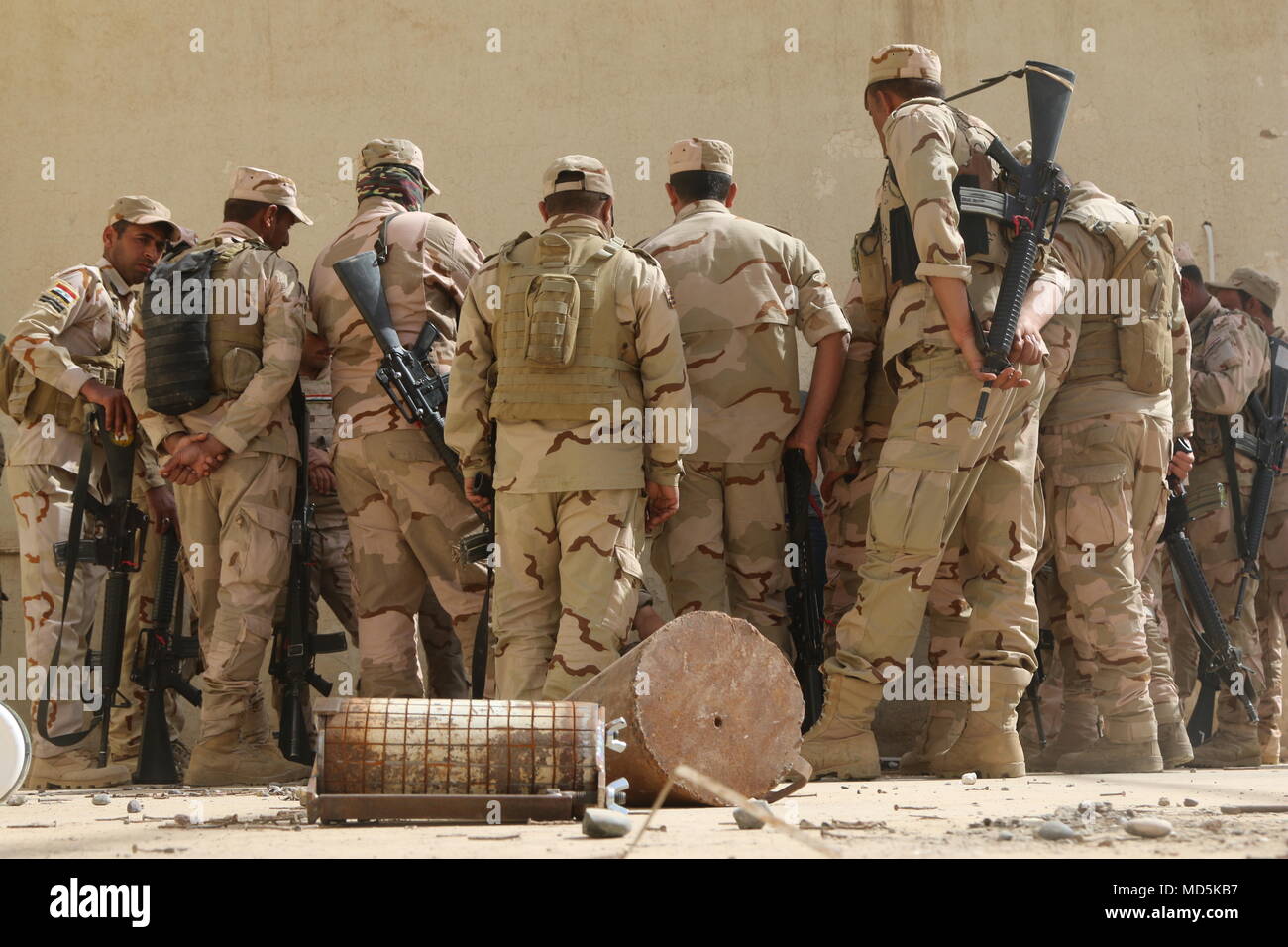 As neutralized Improvised Explosive Devices looms behind them, Iraqi ...