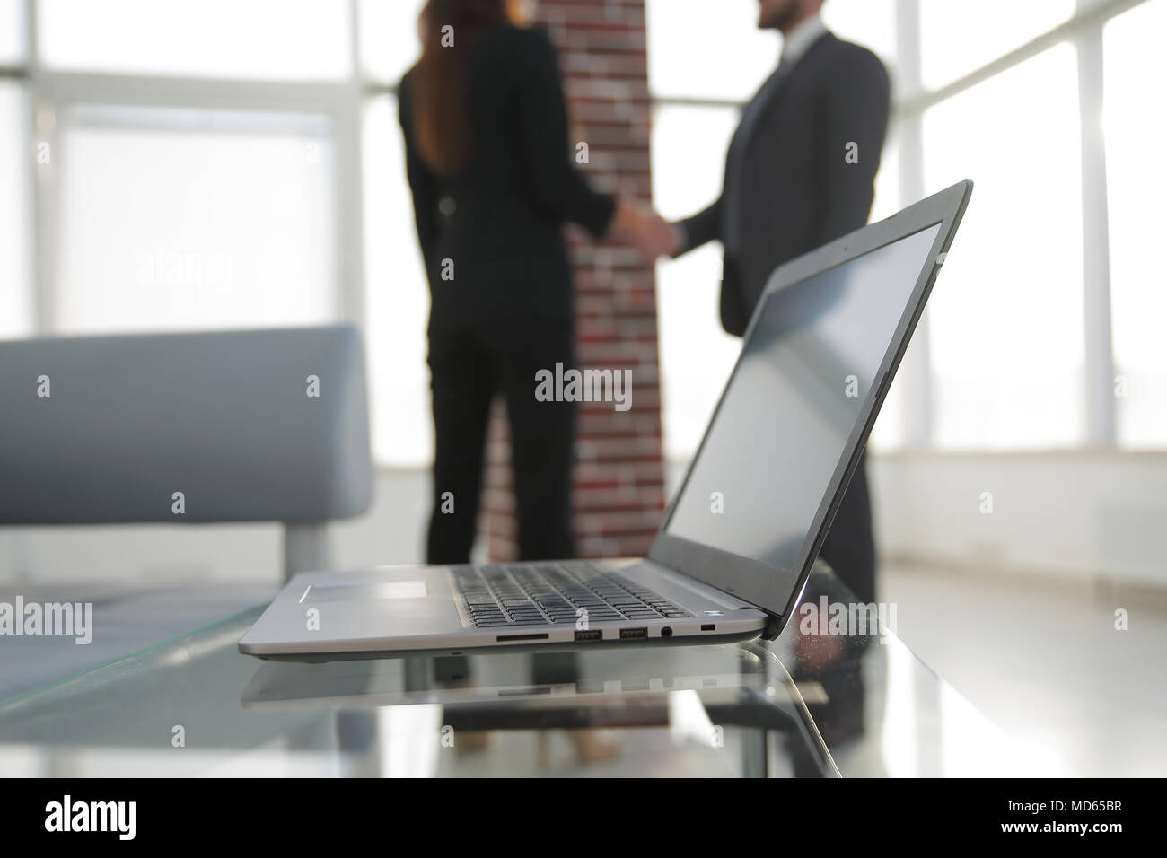 laptop on the desk, background handshake Stock Photo - Alamy