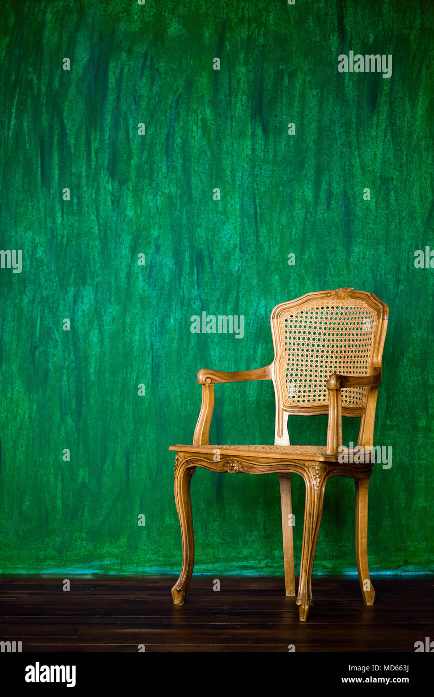 old chair on a green wall background Stock Photo - Alamy