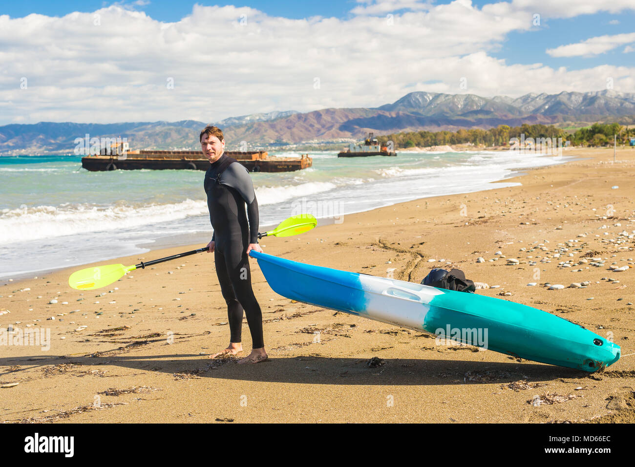 man carrying kayak at sea beach Stock Photo - Alamy