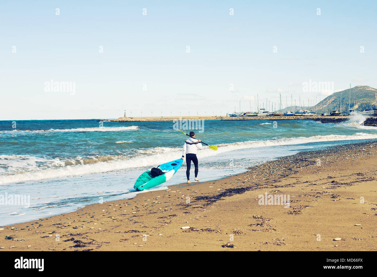 man carrying kayak at sea beach Stock Photo - Alamy