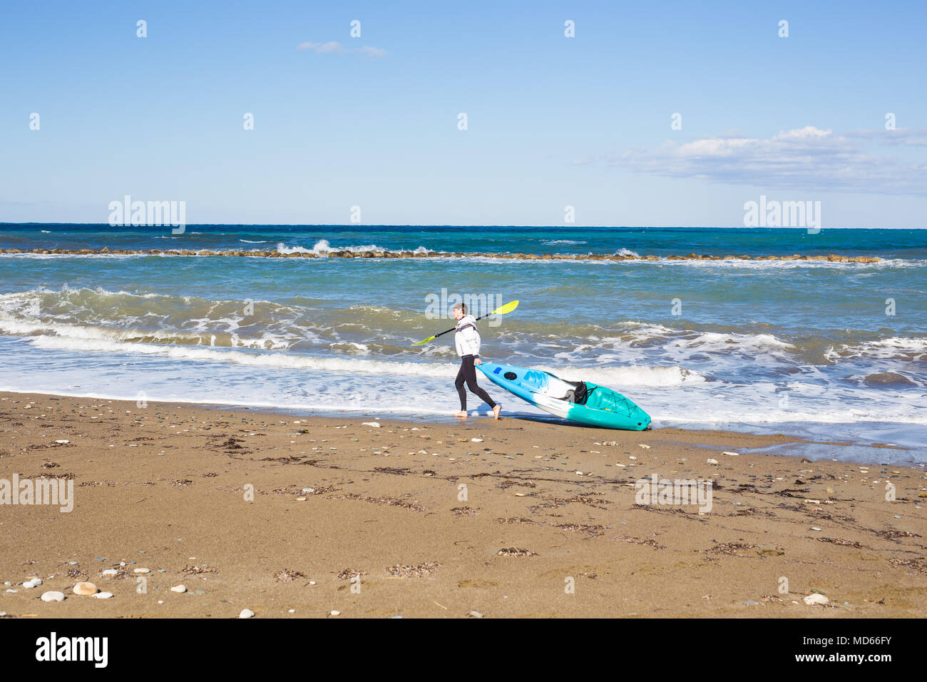 man carrying kayak at sea beach Stock Photo - Alamy