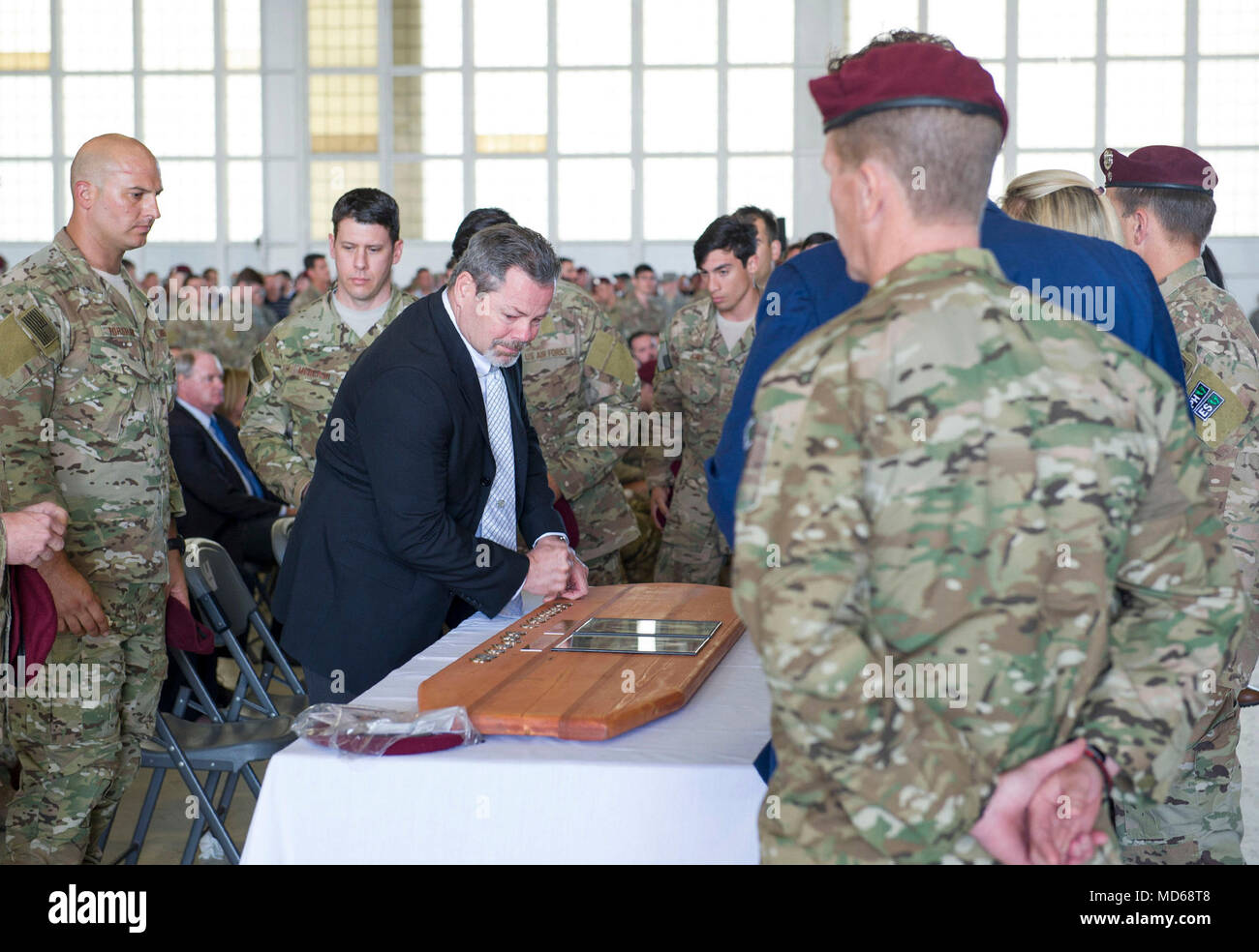 A retired U.S. Air Force pararescueman punches the flash from his beret ...