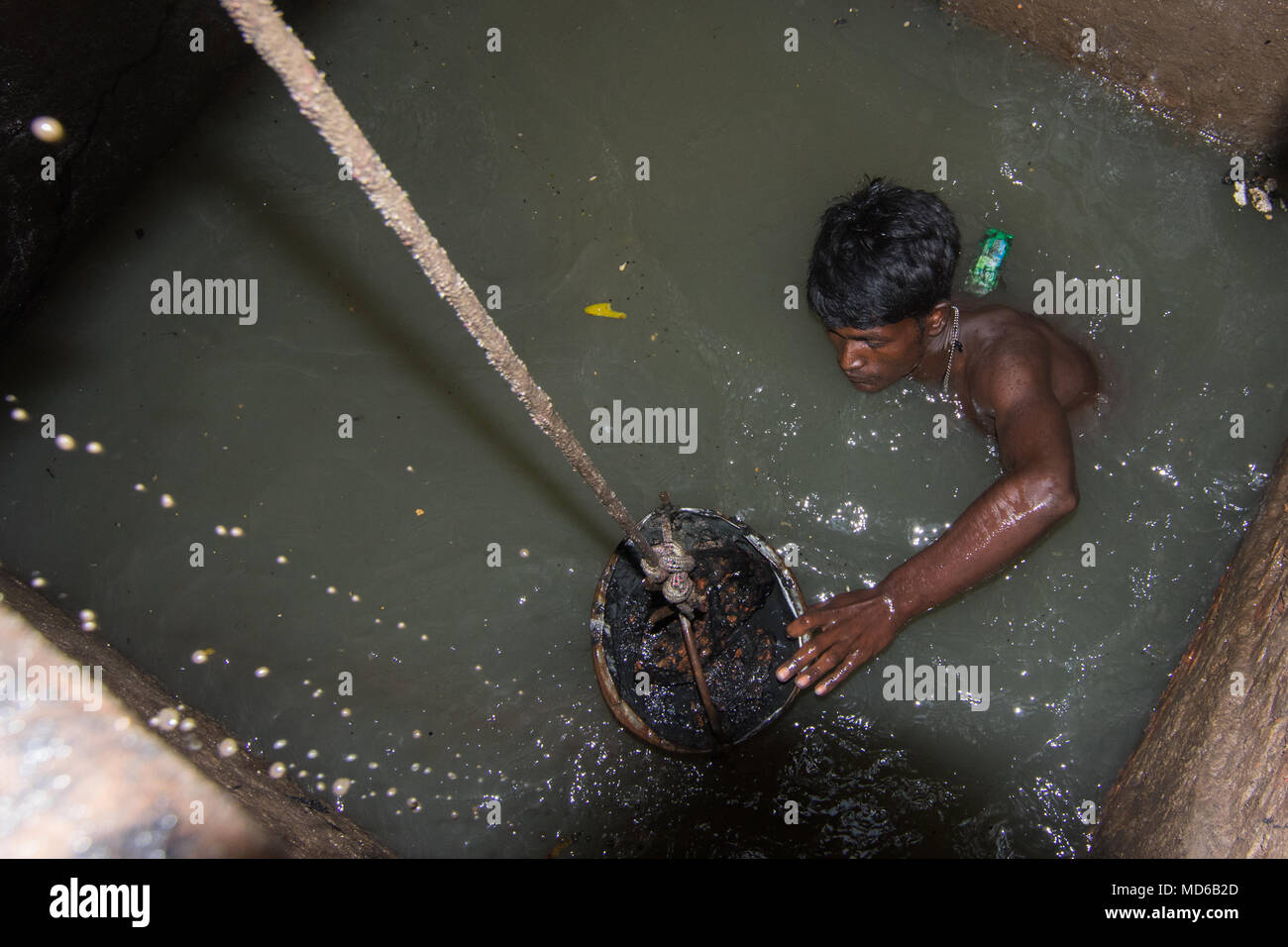Worst job in the world, Diving down into a hole of sludge with his bare ...