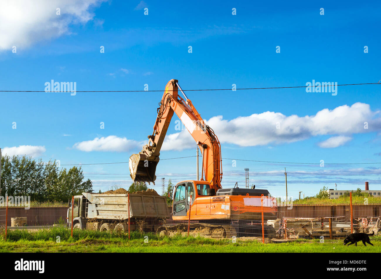 Excavator bucket loads heavy truck with ground on construction of ...
