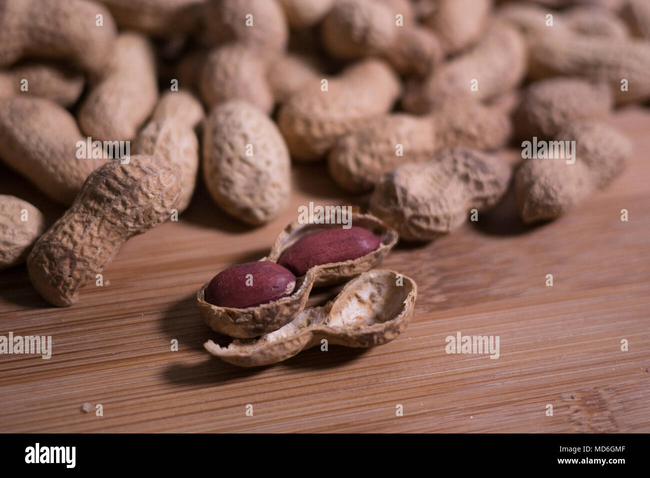 Pile of unshelled natural peanuts in the shell on a natural wooden ...