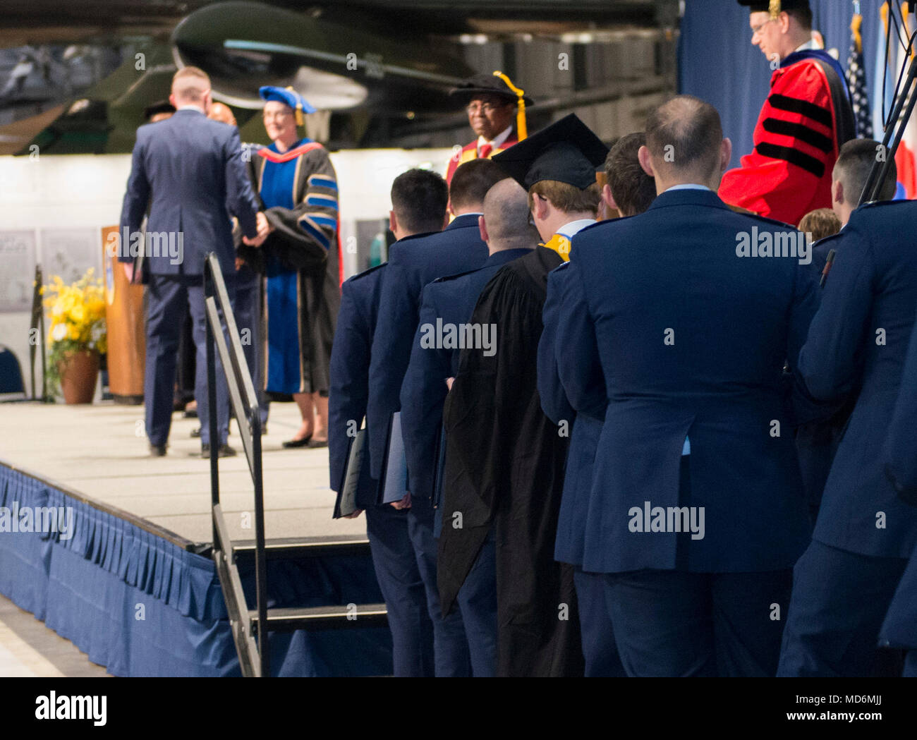 Students line up to cross the stage and shake hands with Secretary of ...